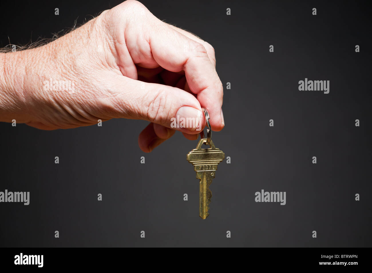 older man's hand holding key ring and key Stock Photo - Alamy