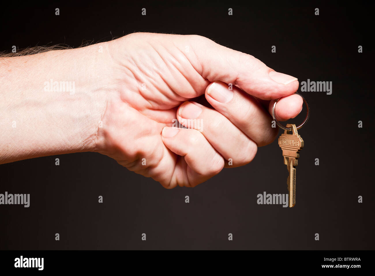 older man's hand holding key ring and key Stock Photo - Alamy