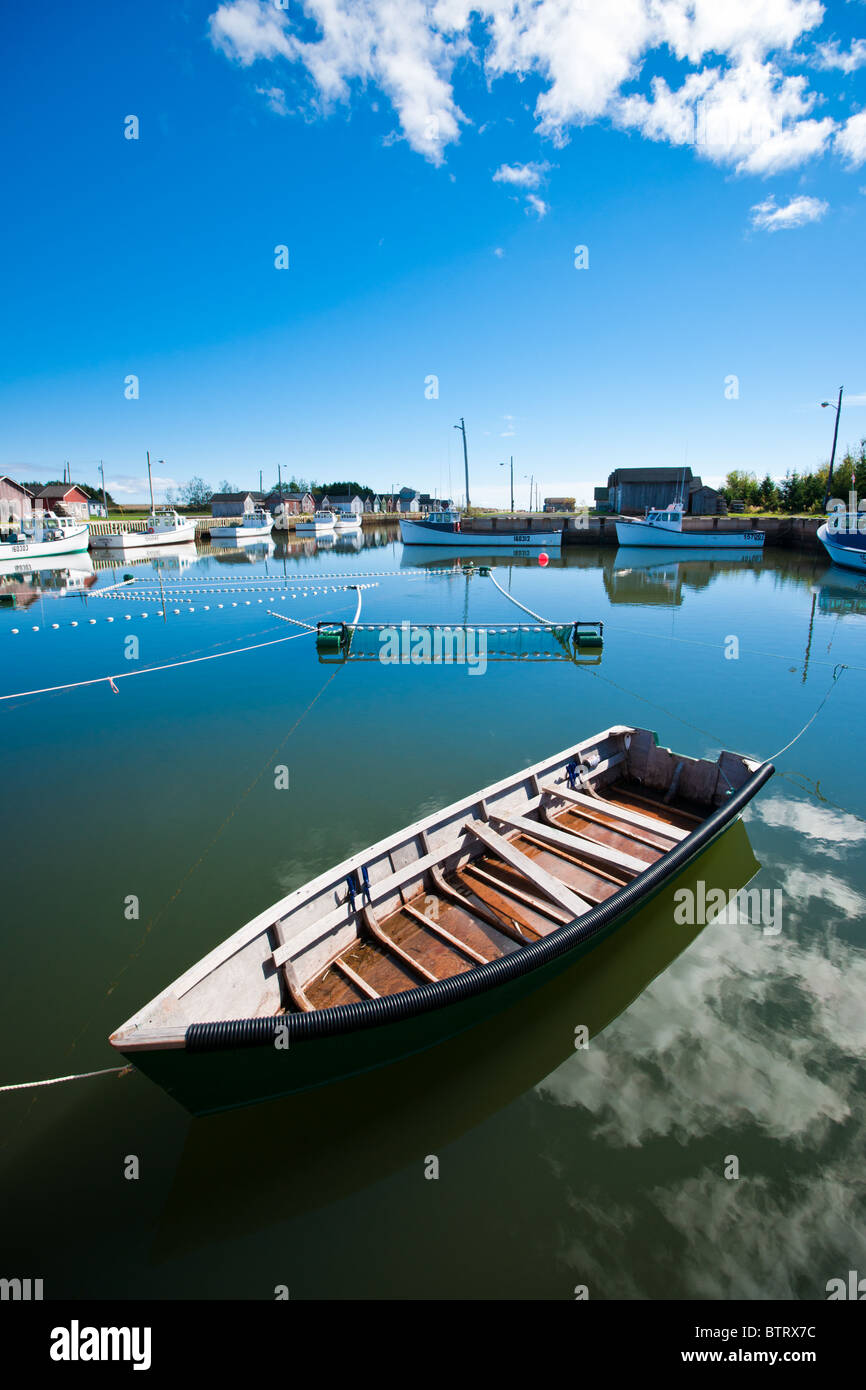 Boats are reflected in the smooth water of Launching Harbour in PEI ...