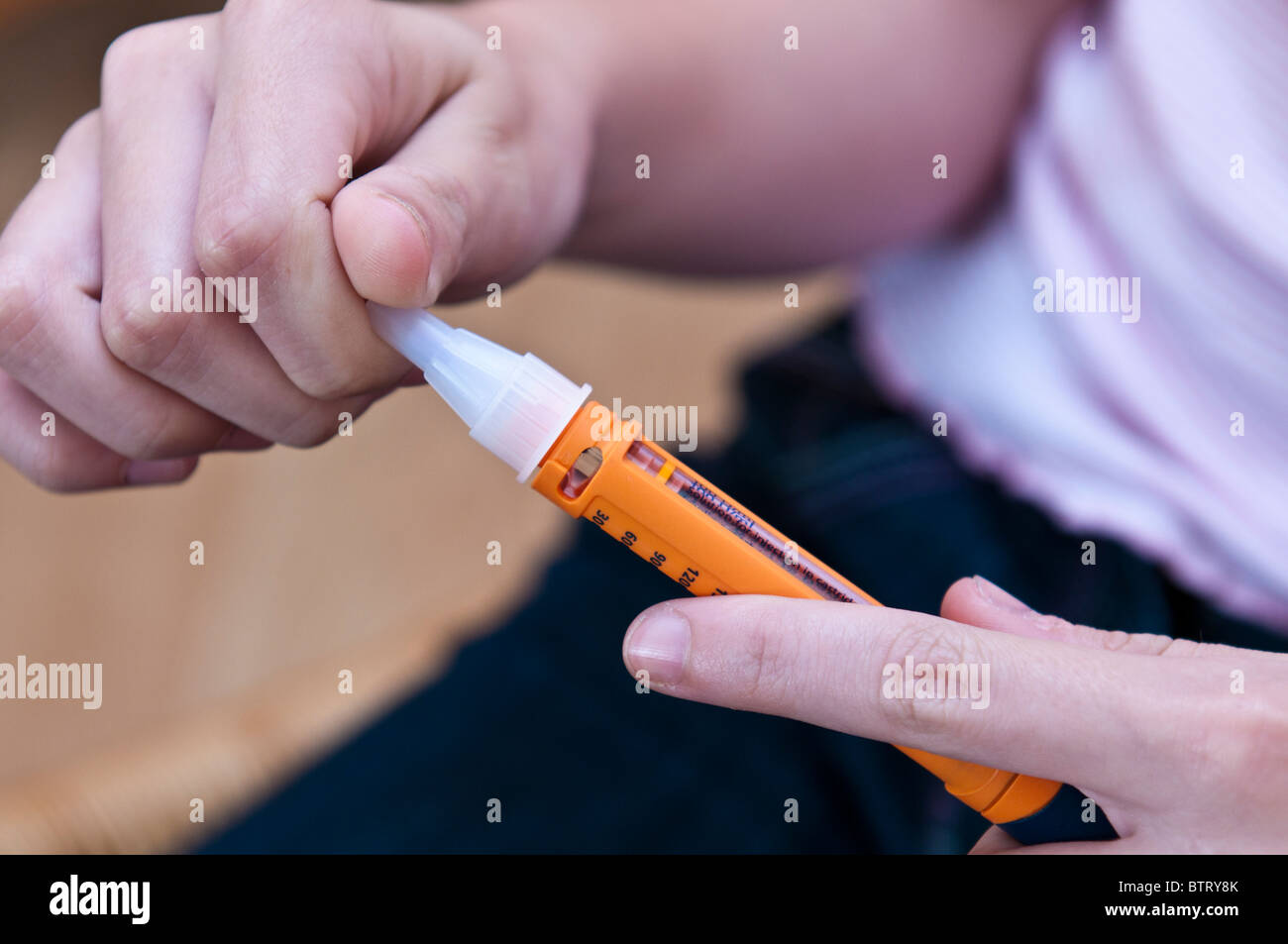 Young diabetic girl prepares an injection of insulin to treat diabetes ...