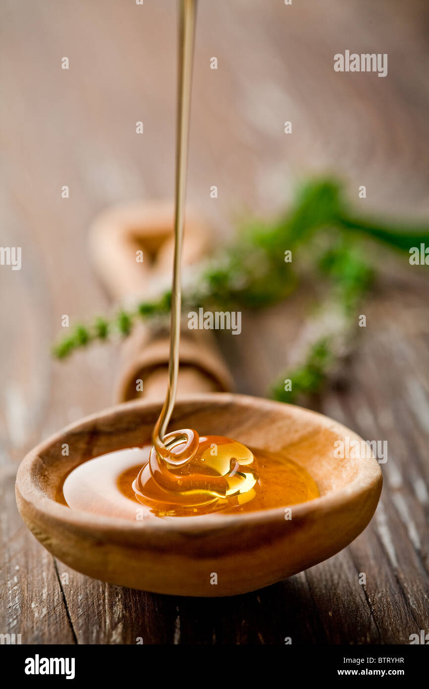 wooden spoon with wild honey falling into it Stock Photo - Alamy