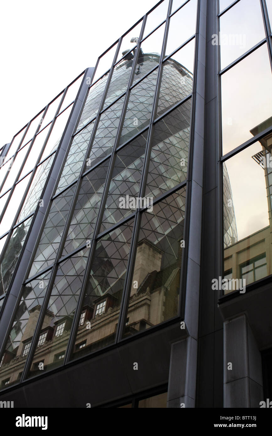 A reflection of the Gherkin building, seen in the glass facade of ...