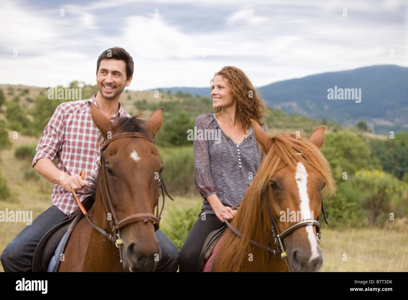 Couple riding horses Stock Photo - Alamy