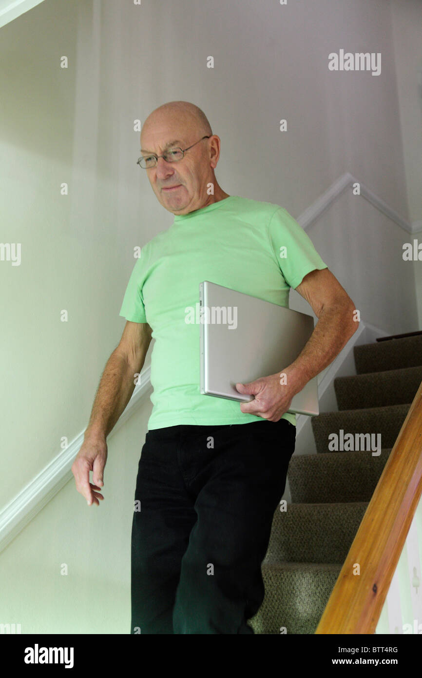 Older man carrying laptop Stock Photo - Alamy