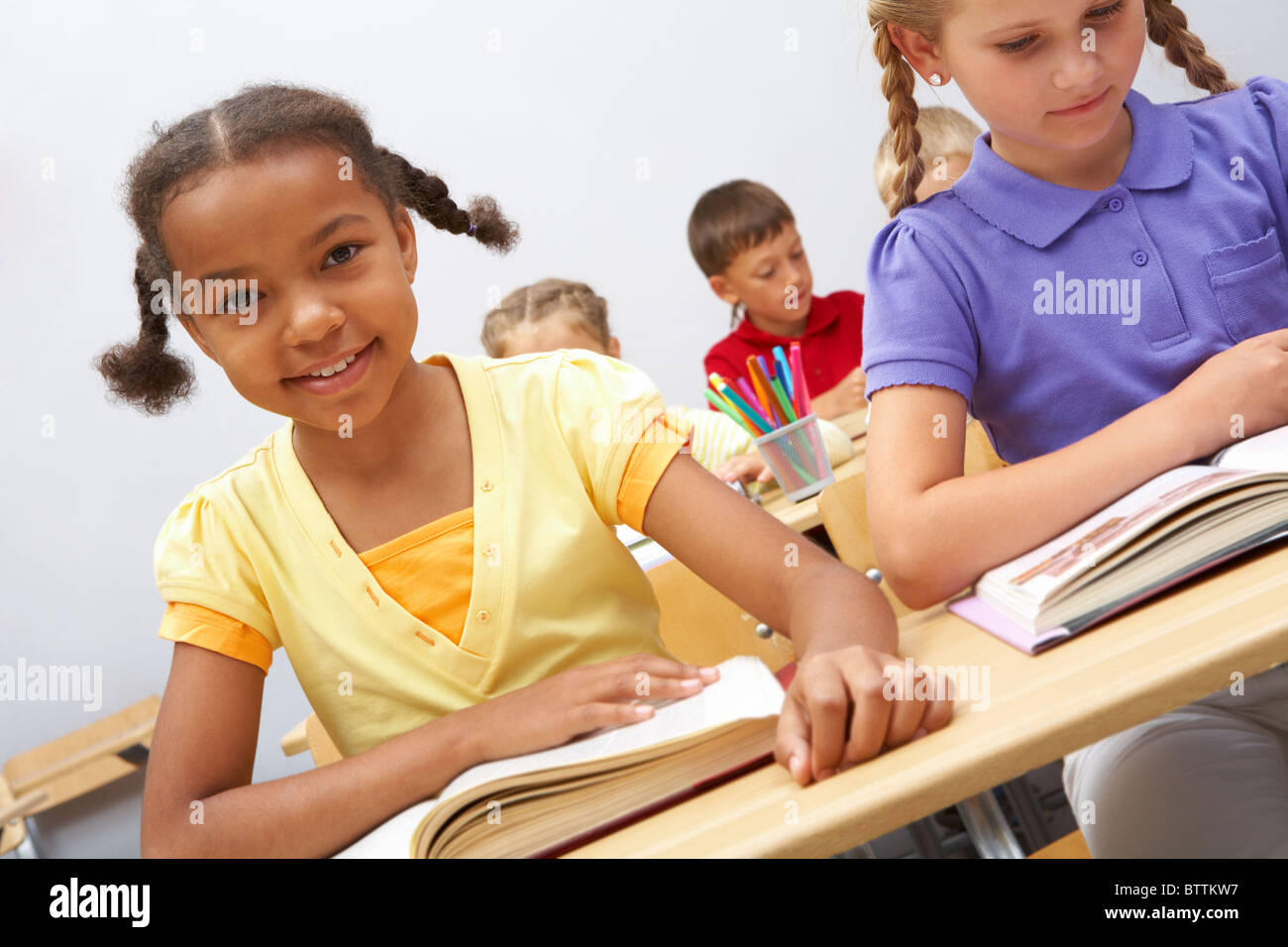 Portrait of smart pupils sitting in the classroom and reading Stock ...