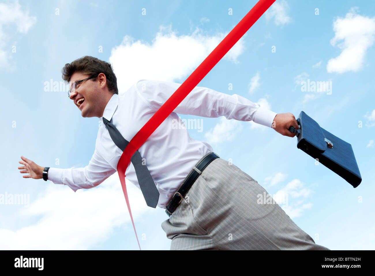 Photo of happy businessman crossing finish line during race Stock Photo ...