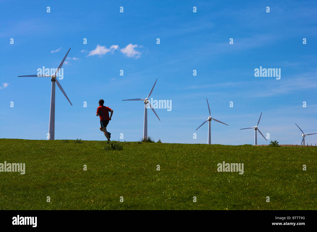Man running by wind turbines Stock Photo - Alamy