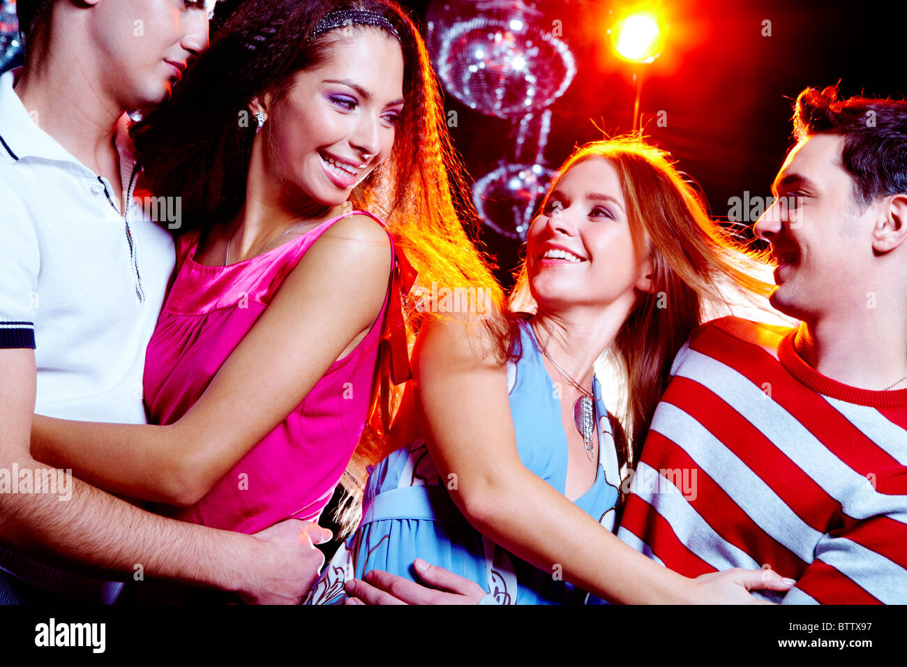 Portrait of laughing couples looking at each other at party Stock Photo ...