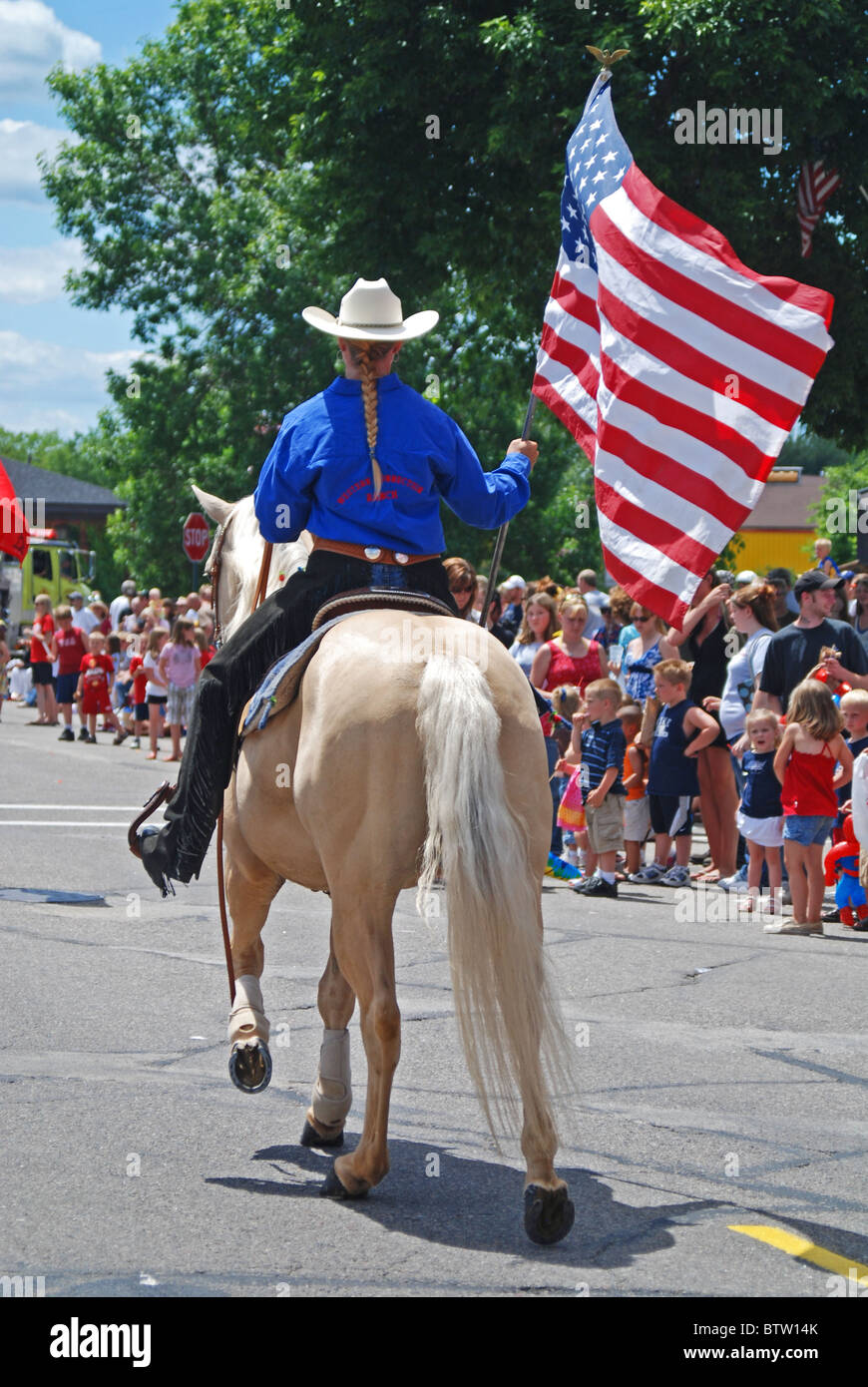 Cowgirl rides her white horse in the July 4th parade in rural America ...