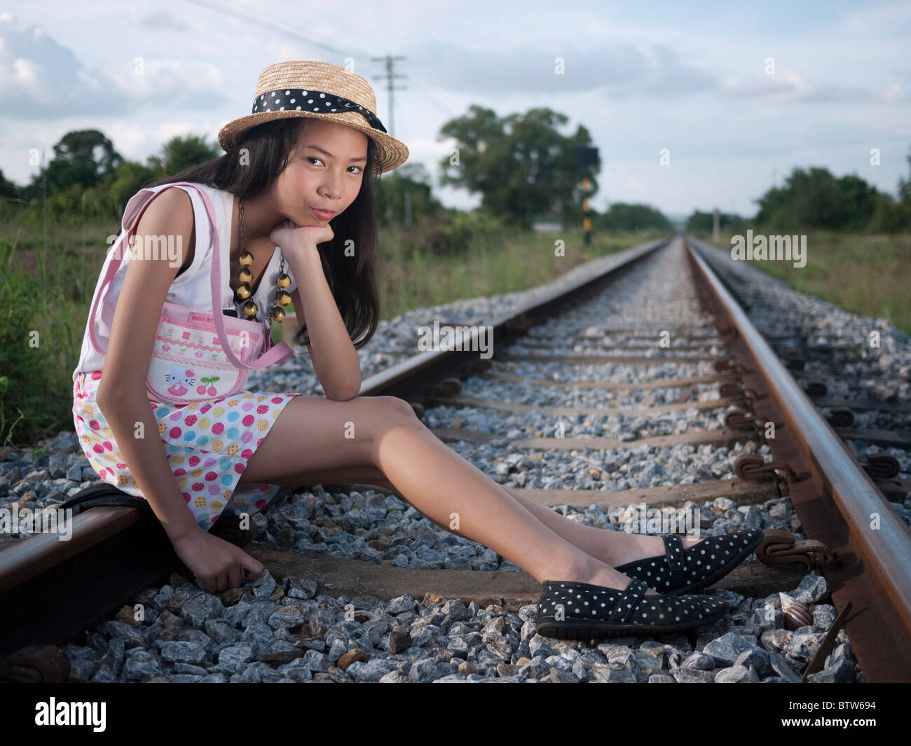 A teenager sits on a railway line Stock Photo - Alamy