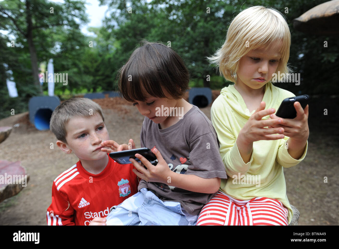 children using the apple iphone at kew gardens, london Stock Photo - Alamy