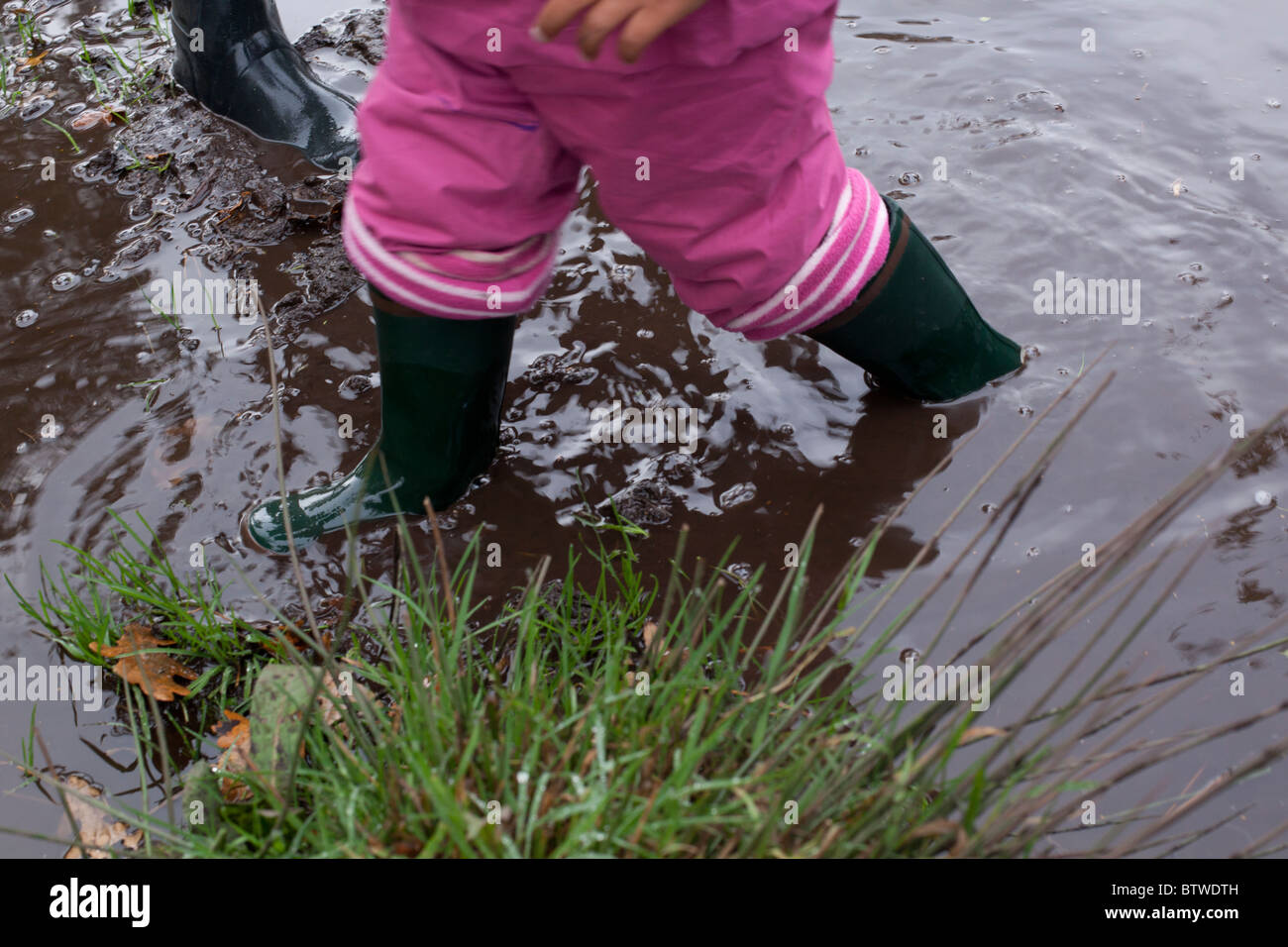 Kids playing in puddle Stock Photo - Alamy