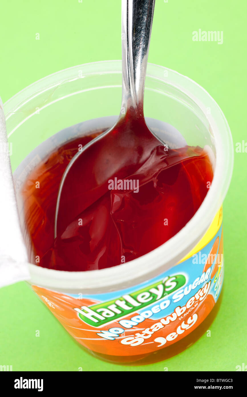 Tablespoon in a container of Hartleys Strawberry jelly Stock Photo - Alamy