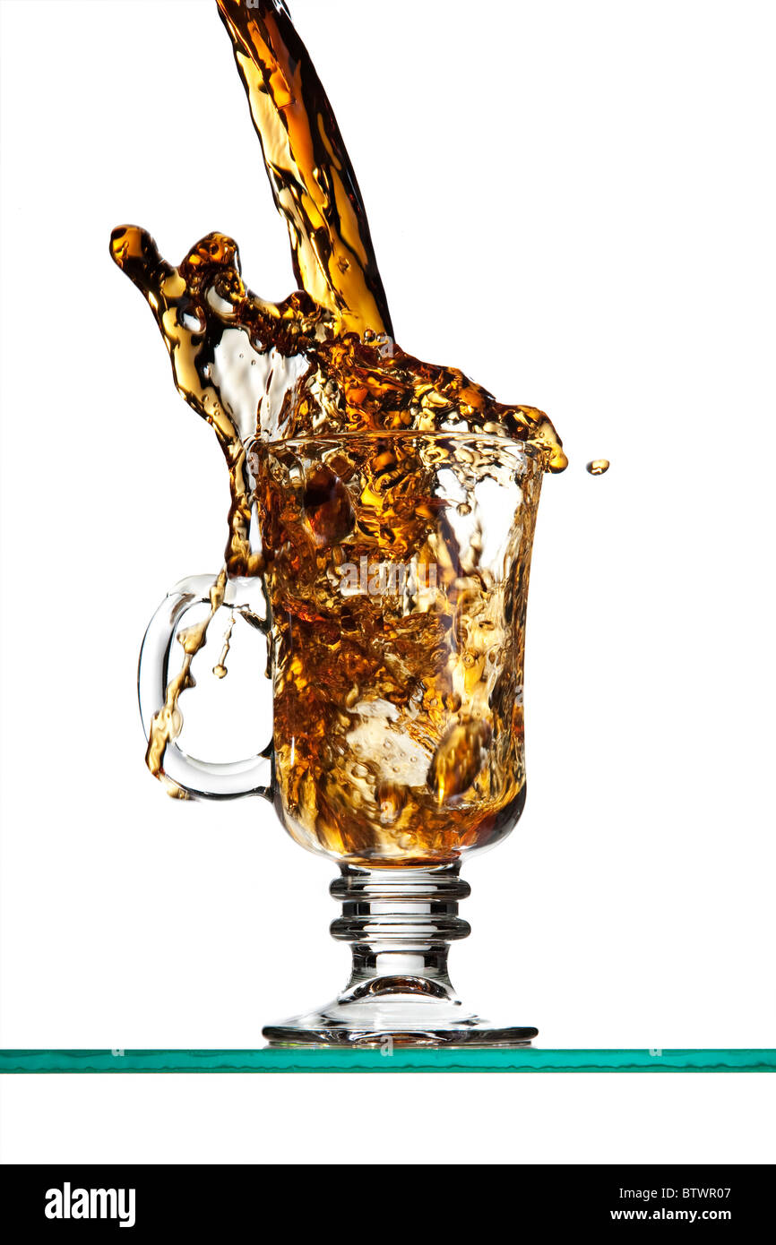 Pouring a cup of coffee, coffee overflowing and spilling onto the table ...