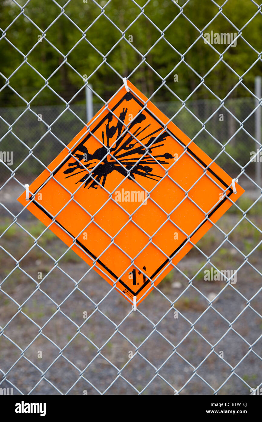 Orange Explosives symbol sign attached to wire-netting fence Stock ...