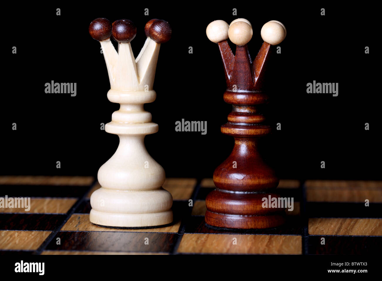 Two queens on a chess board. Isolated on black Stock Photo - Alamy