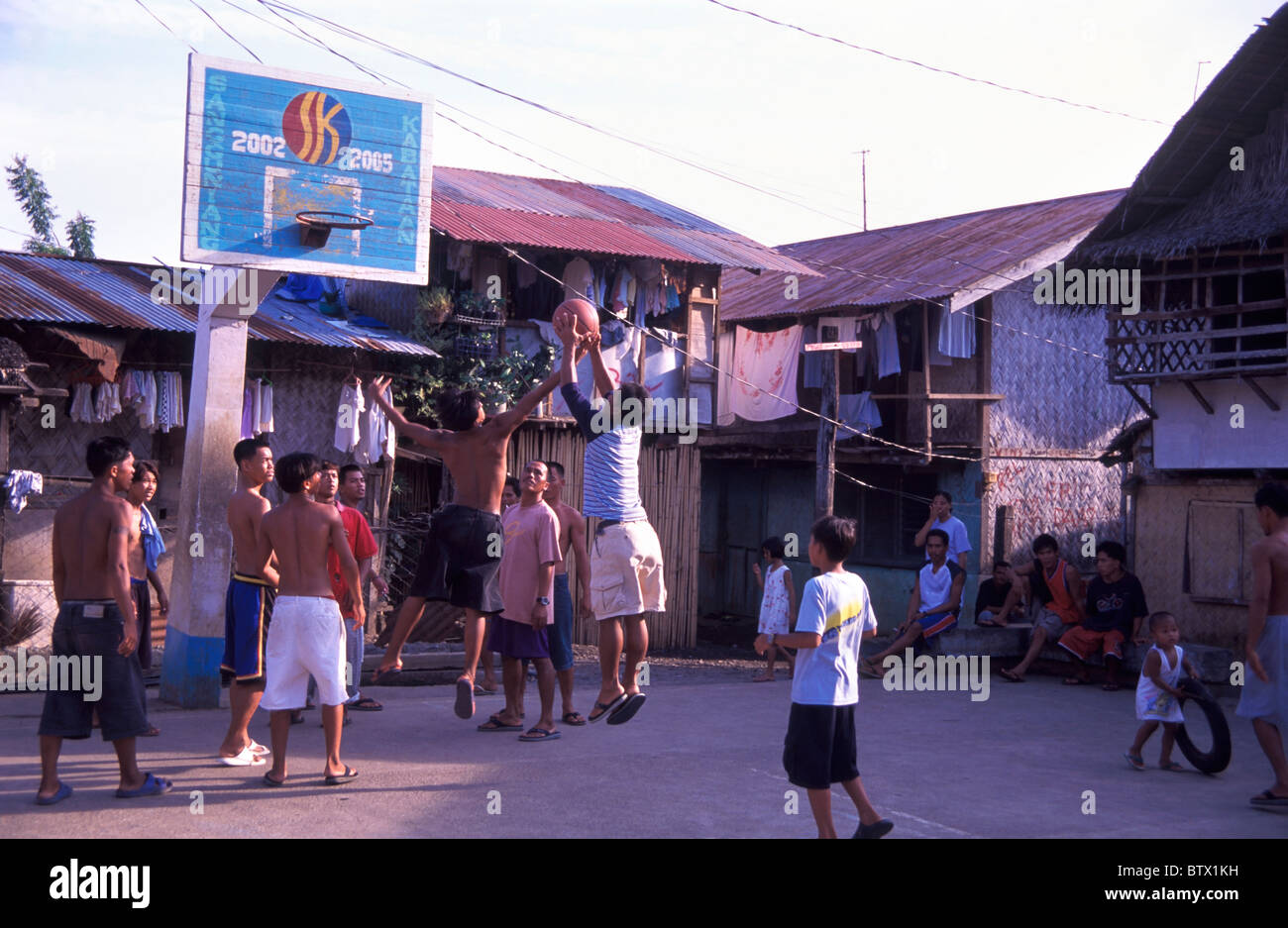 Inhabitants in a slum play basketball in village in the Philippines ...