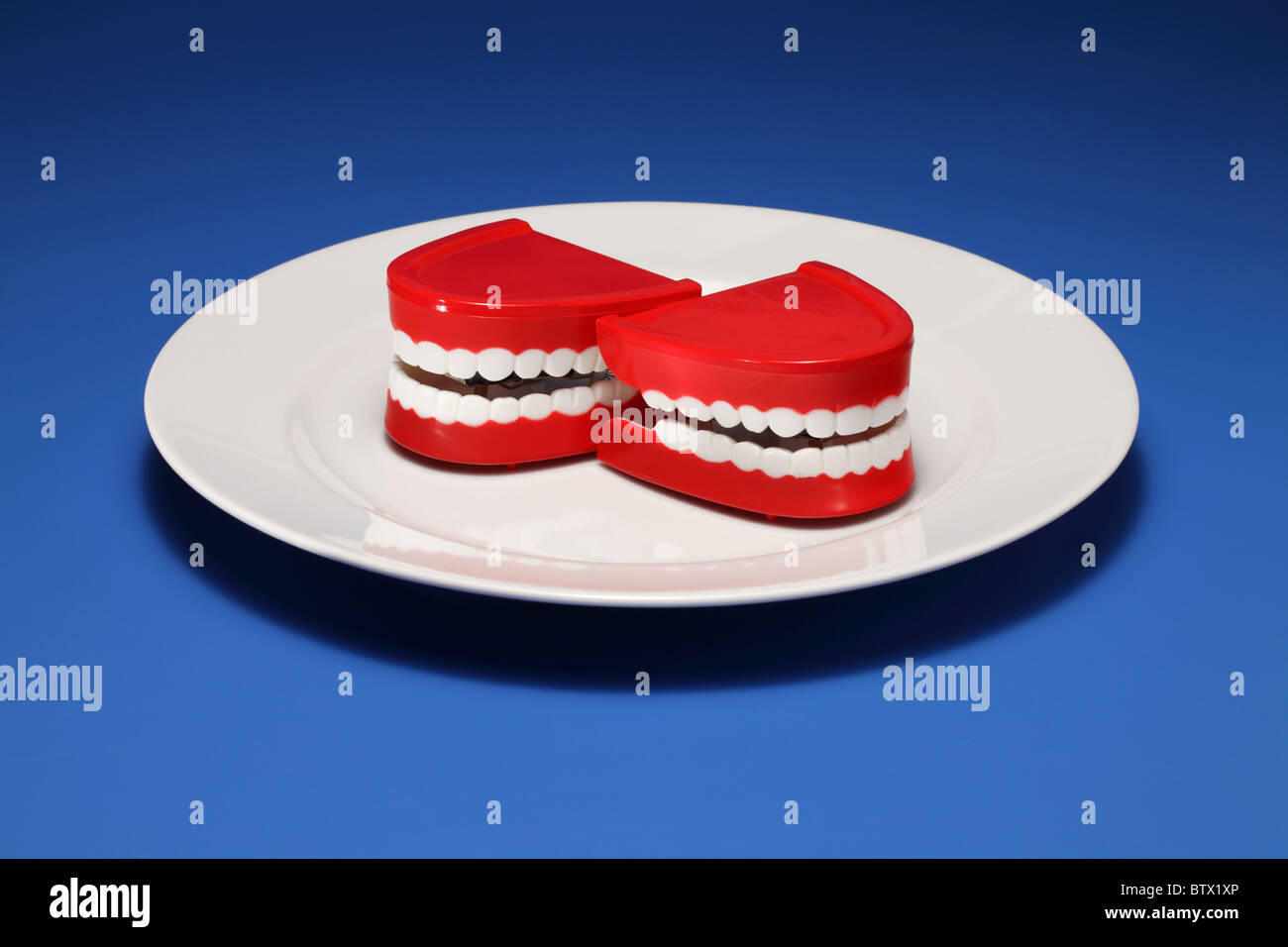 Two plastic gums and teeth on a white dinner plate Stock Photo - Alamy