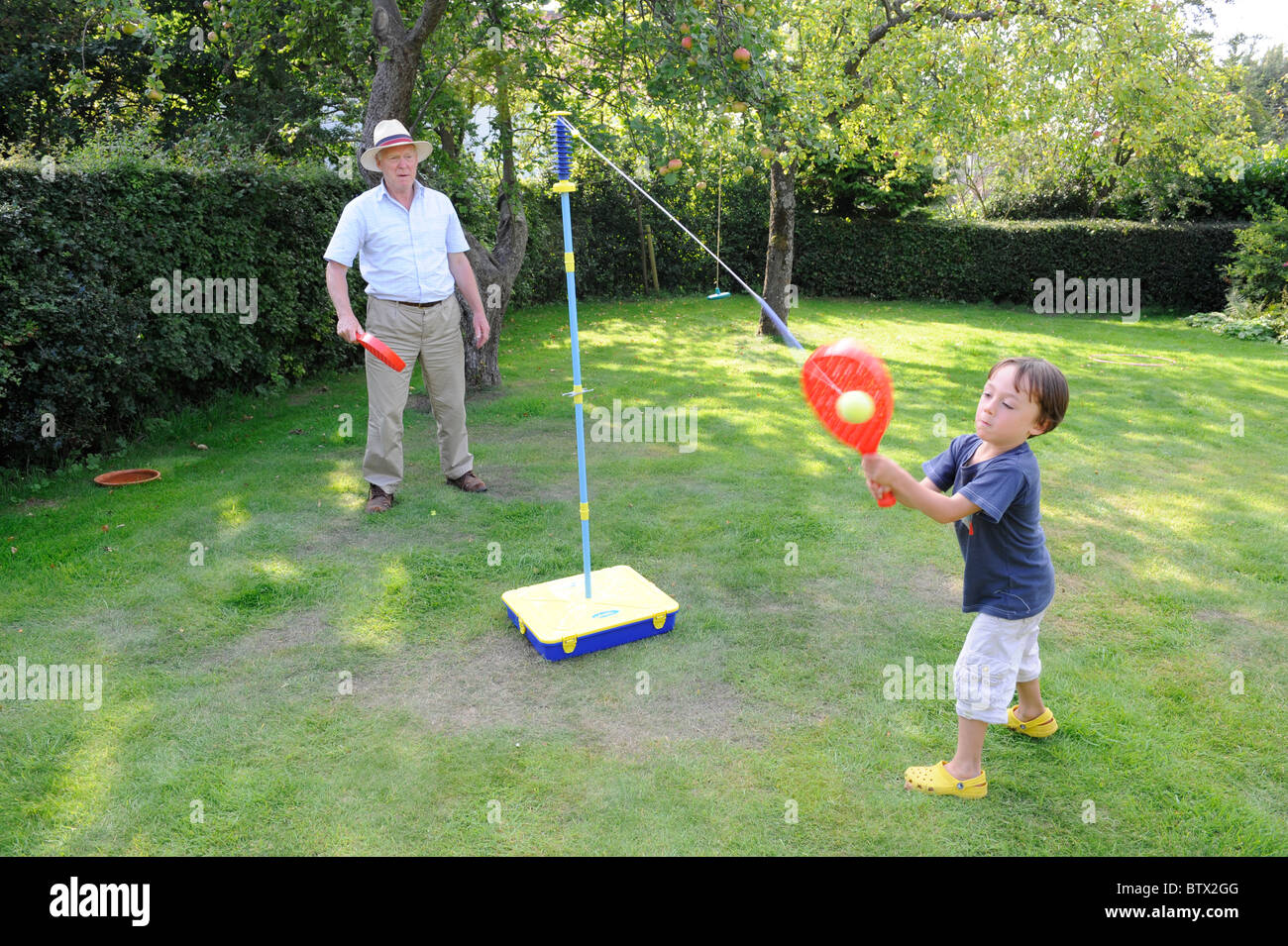 grandfather playing swingball in garden Stock Photo - Alamy