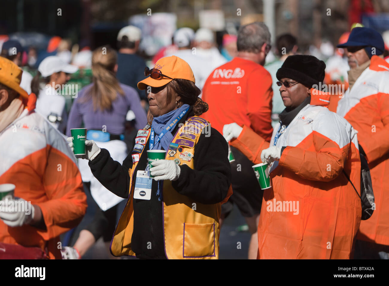 Volunteers at a fluid station hand out water and Gatorade to runners ...