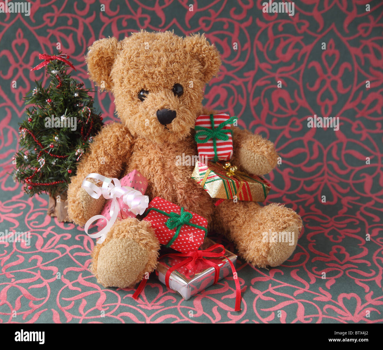 toy bear with brightly wrapped gifts and a small Christmas tree Stock ...