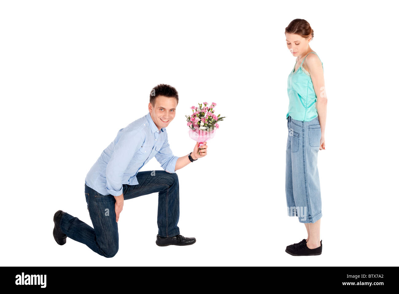 Happy handsome young man handing over a flowers to a beautiful young ...