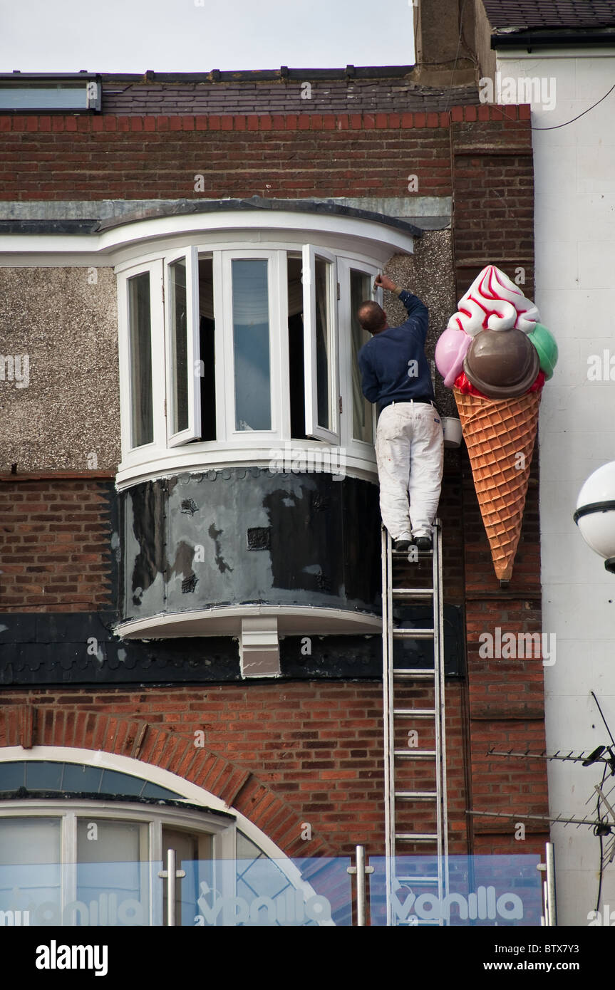 Decorator at work on seaside building Stock Photo - Alamy