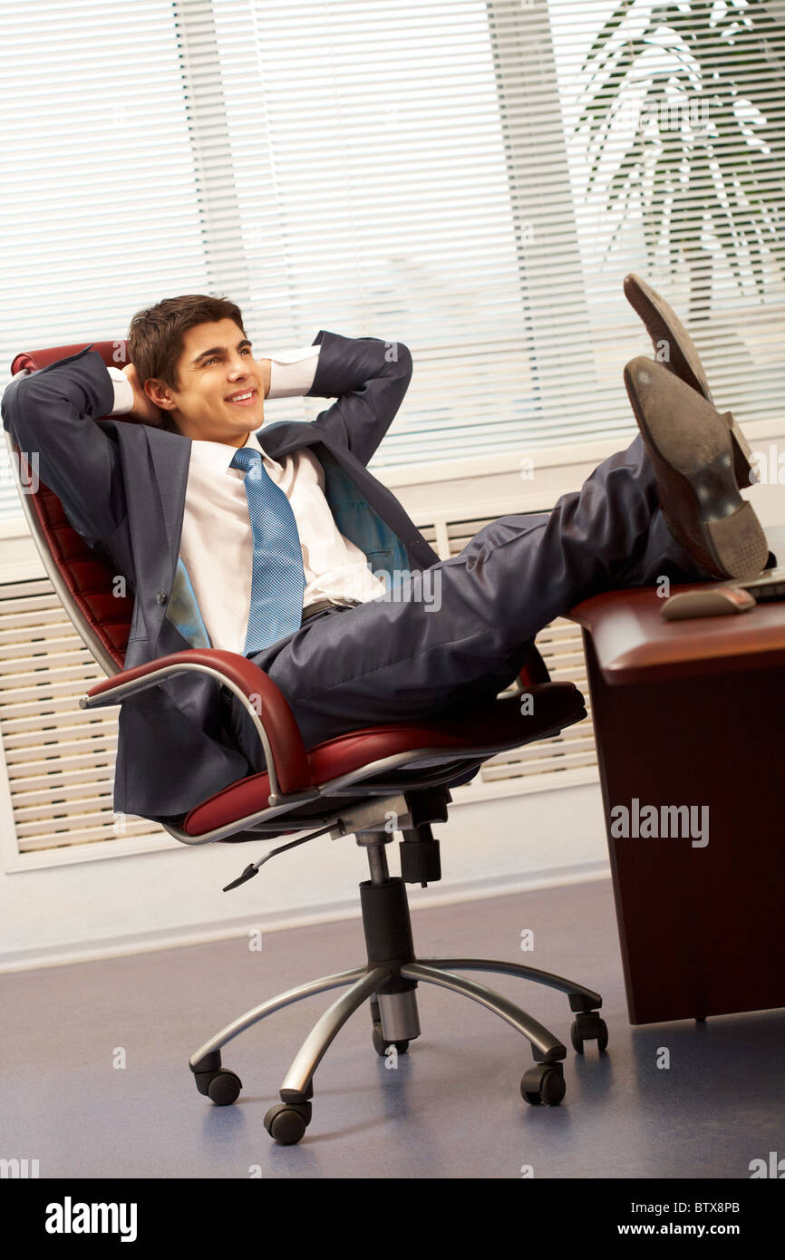 Portrait of handsome employee having rest in arm-chair in office Stock ...