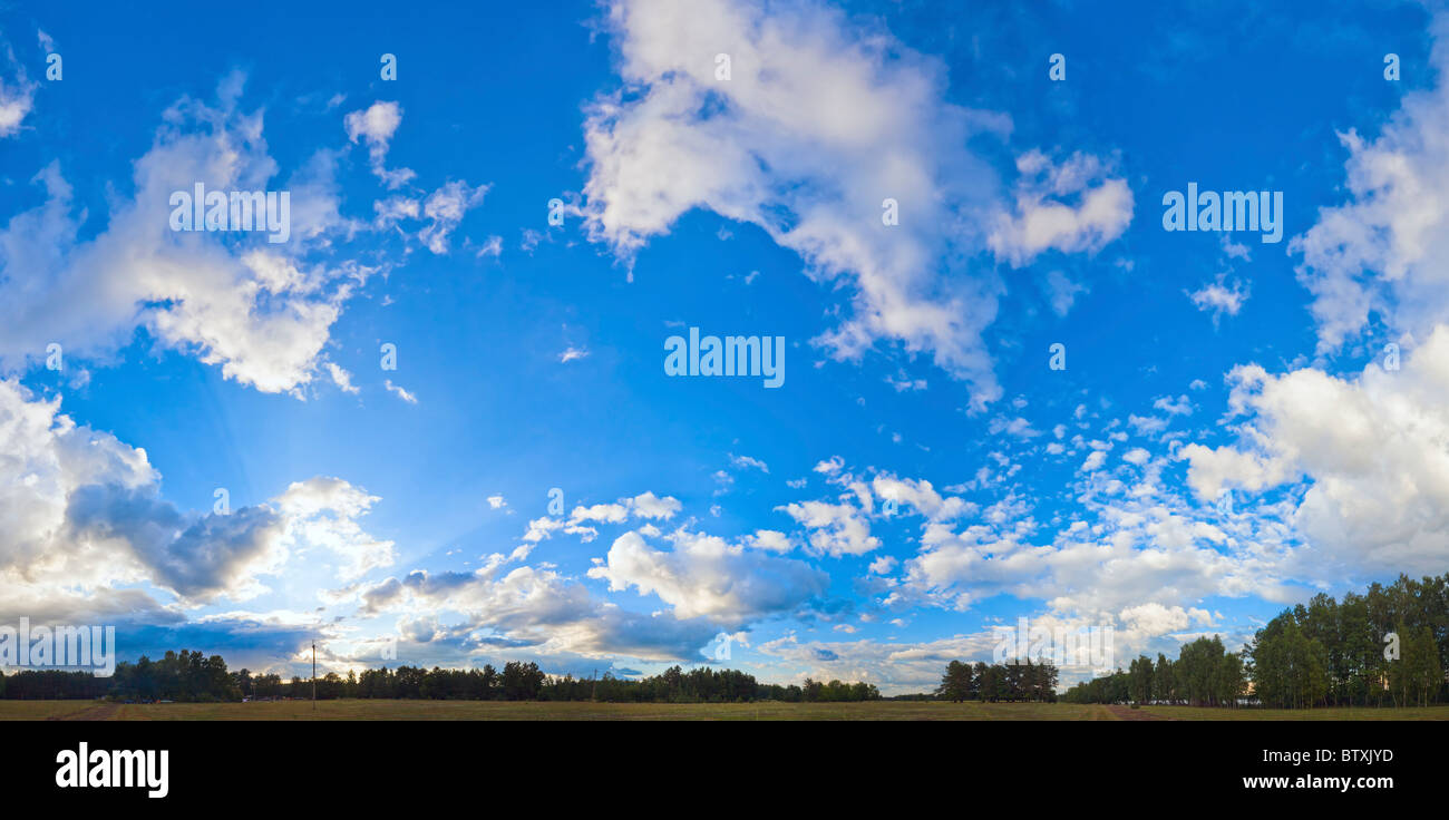 Evening blue sky panorama with clouds over plain and camp on forest ...