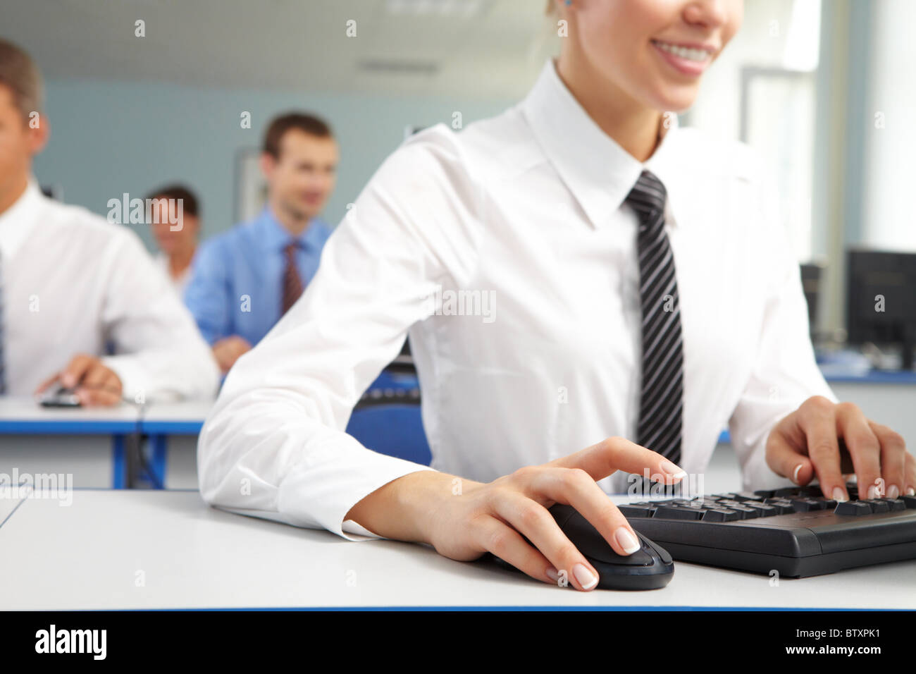 Image of female hand on mouse while typing on keyboard in a working ...