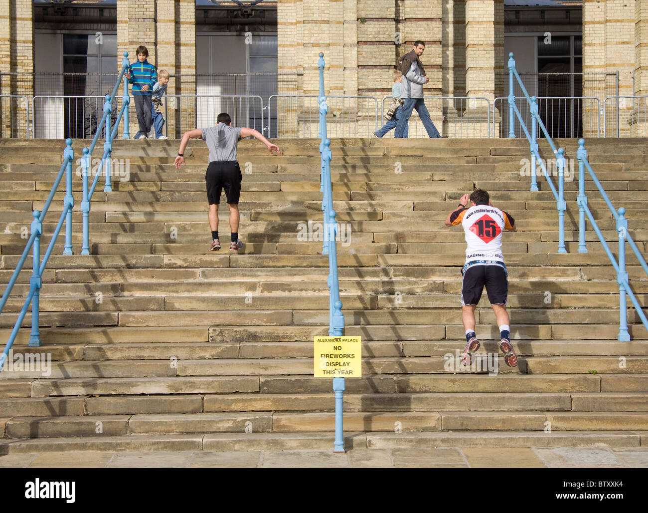 Two men 'working out' with out-door keep fit exercises, jumping up the ...