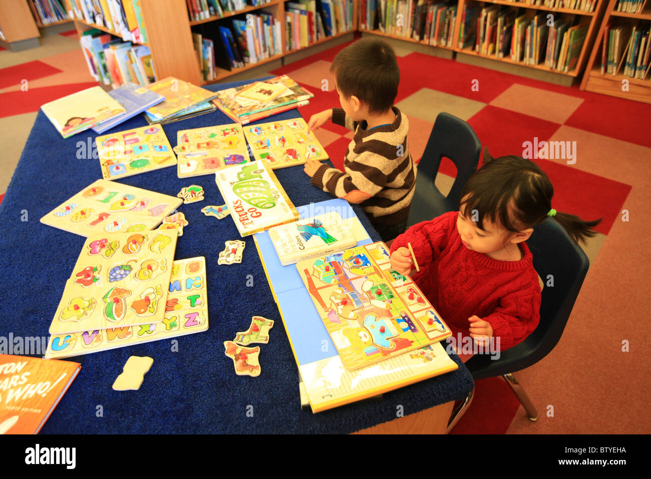 Little kids reading books in library Stock Photo - Alamy
