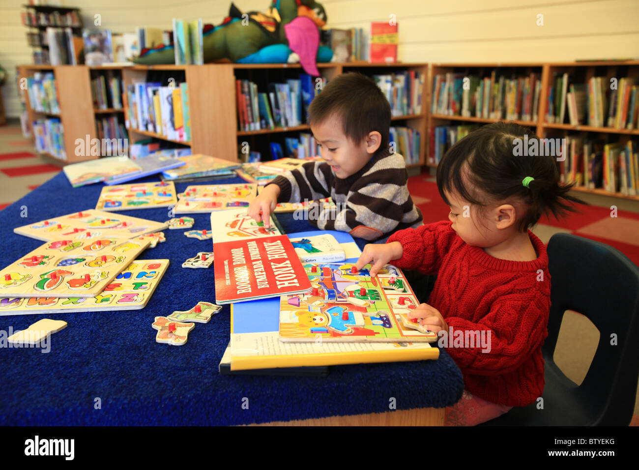 Little kids reading books in library Stock Photo - Alamy