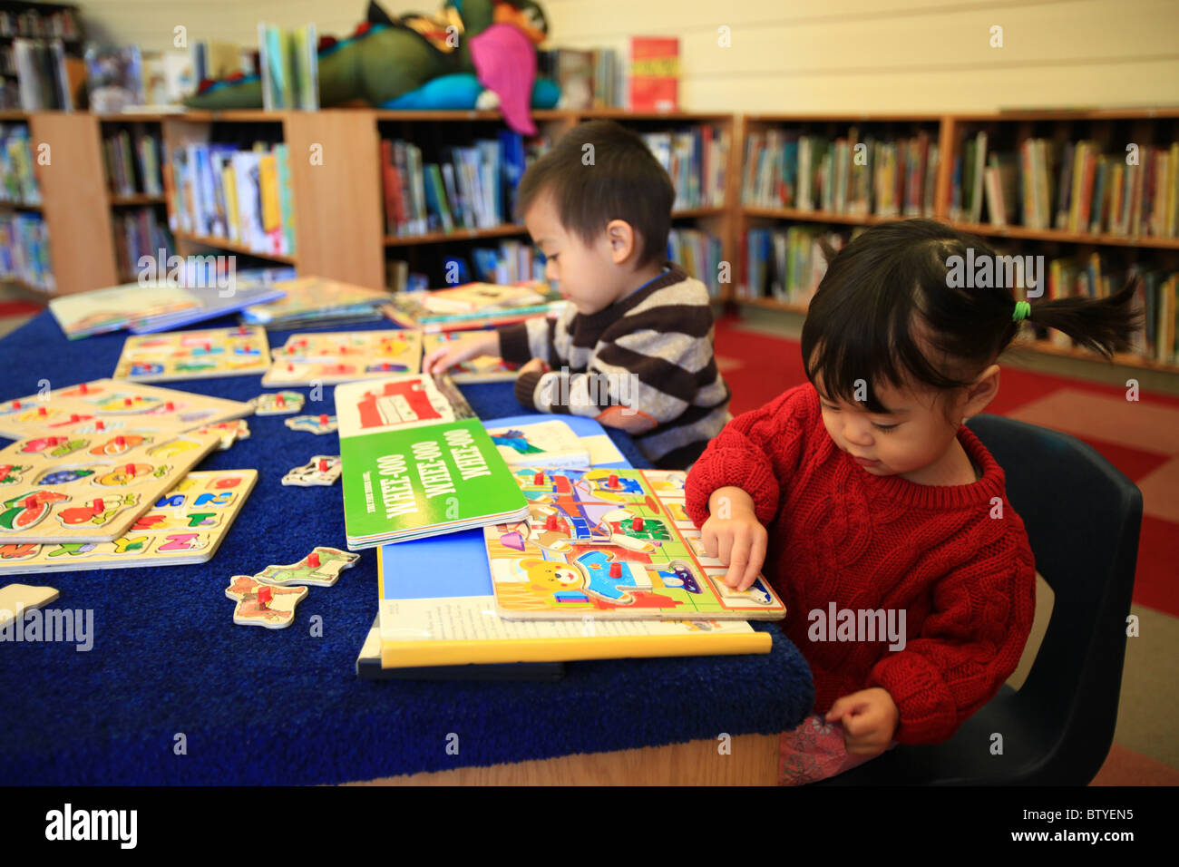 Little kids reading books in library Stock Photo - Alamy