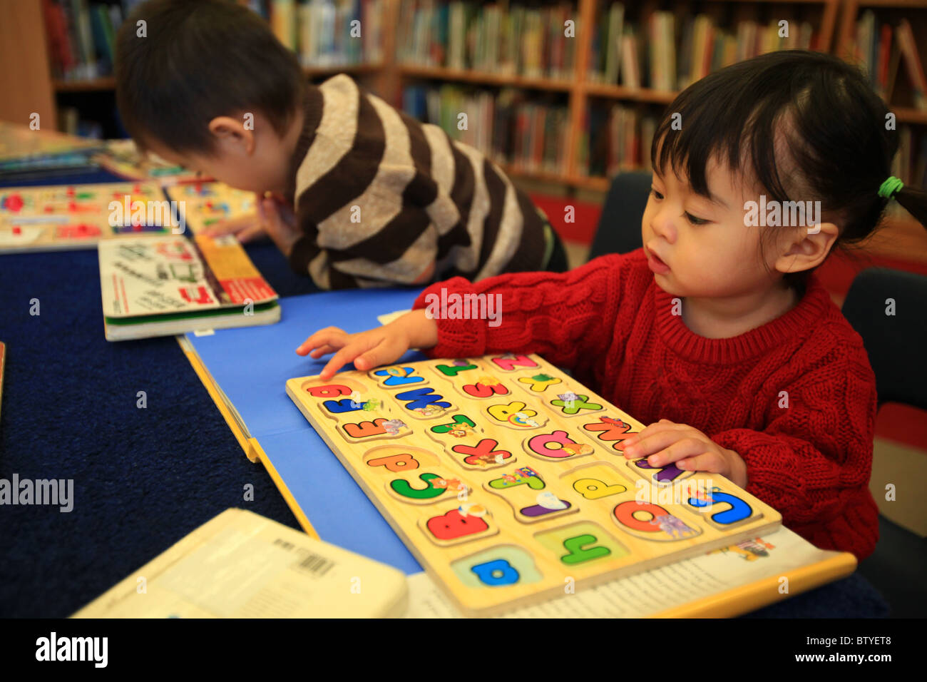 Little kids reading books in library Stock Photo - Alamy