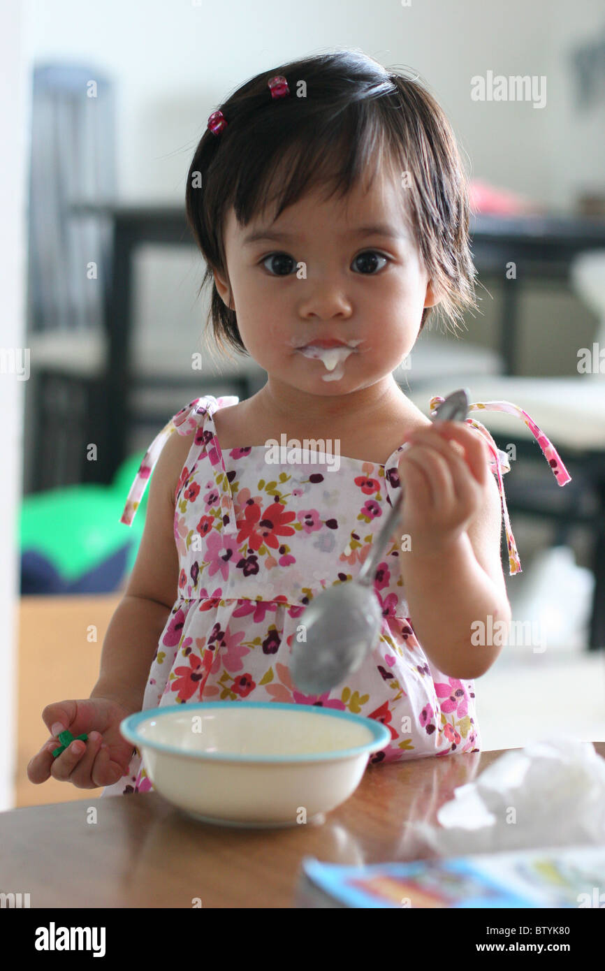 Adorable baby girl eating cream Stock Photo - Alamy