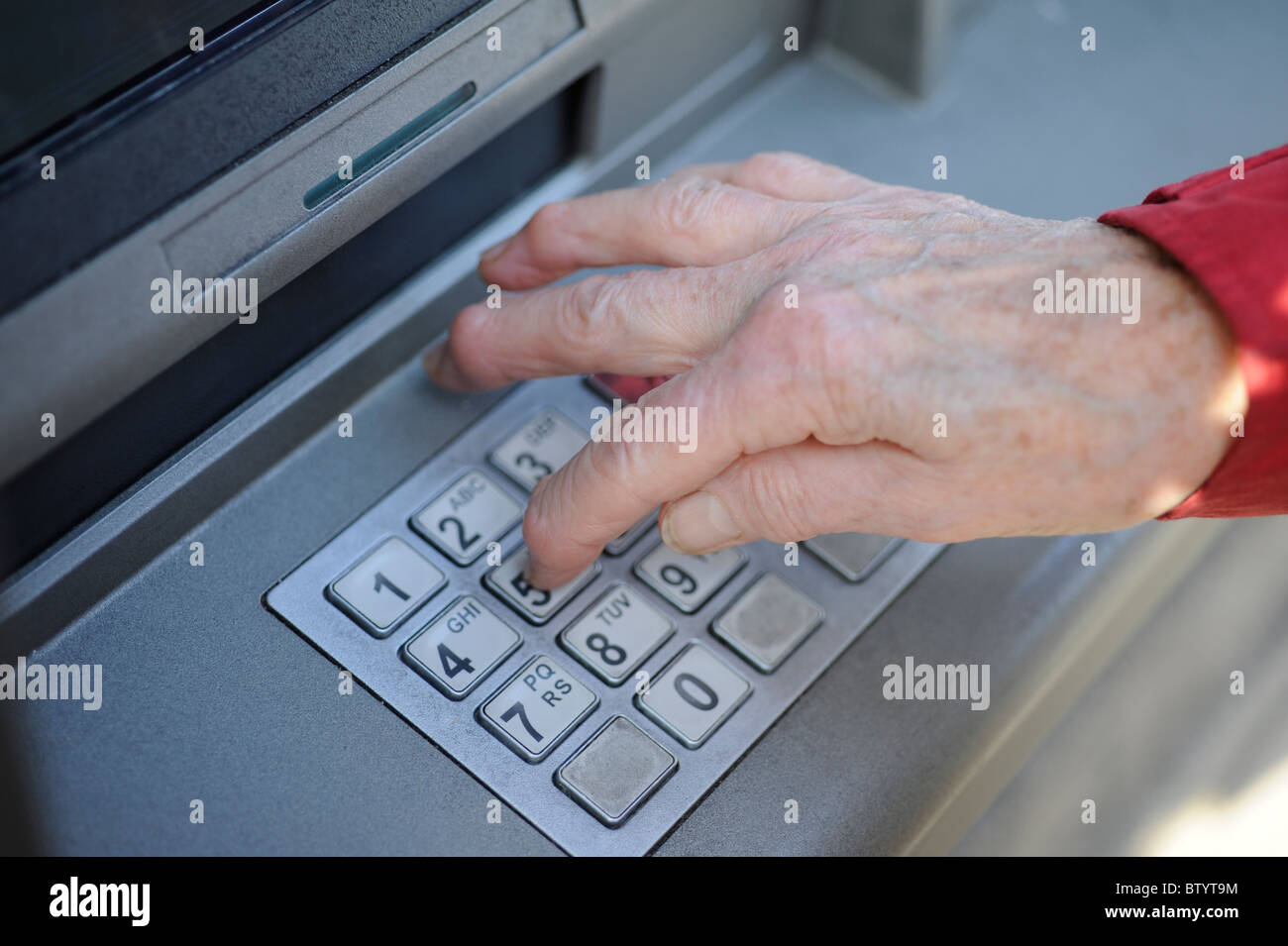 pensioner using cash point in london Stock Photo - Alamy