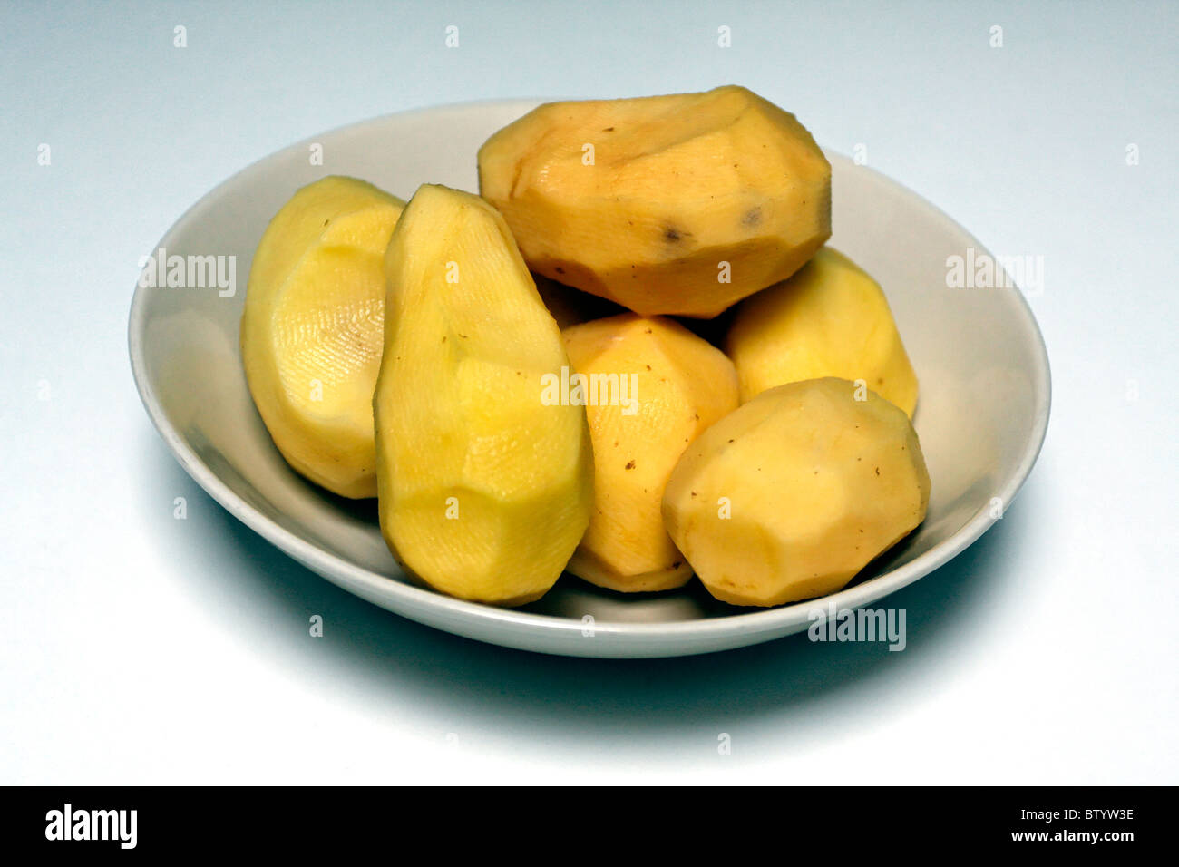 Group of peeled off potatoes ina dish ona white background Stock Photo ...