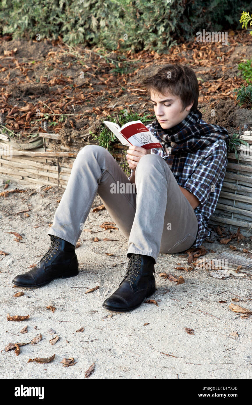 handsome French teenager sittiing on gravel in Notre Dame Cathedral ...