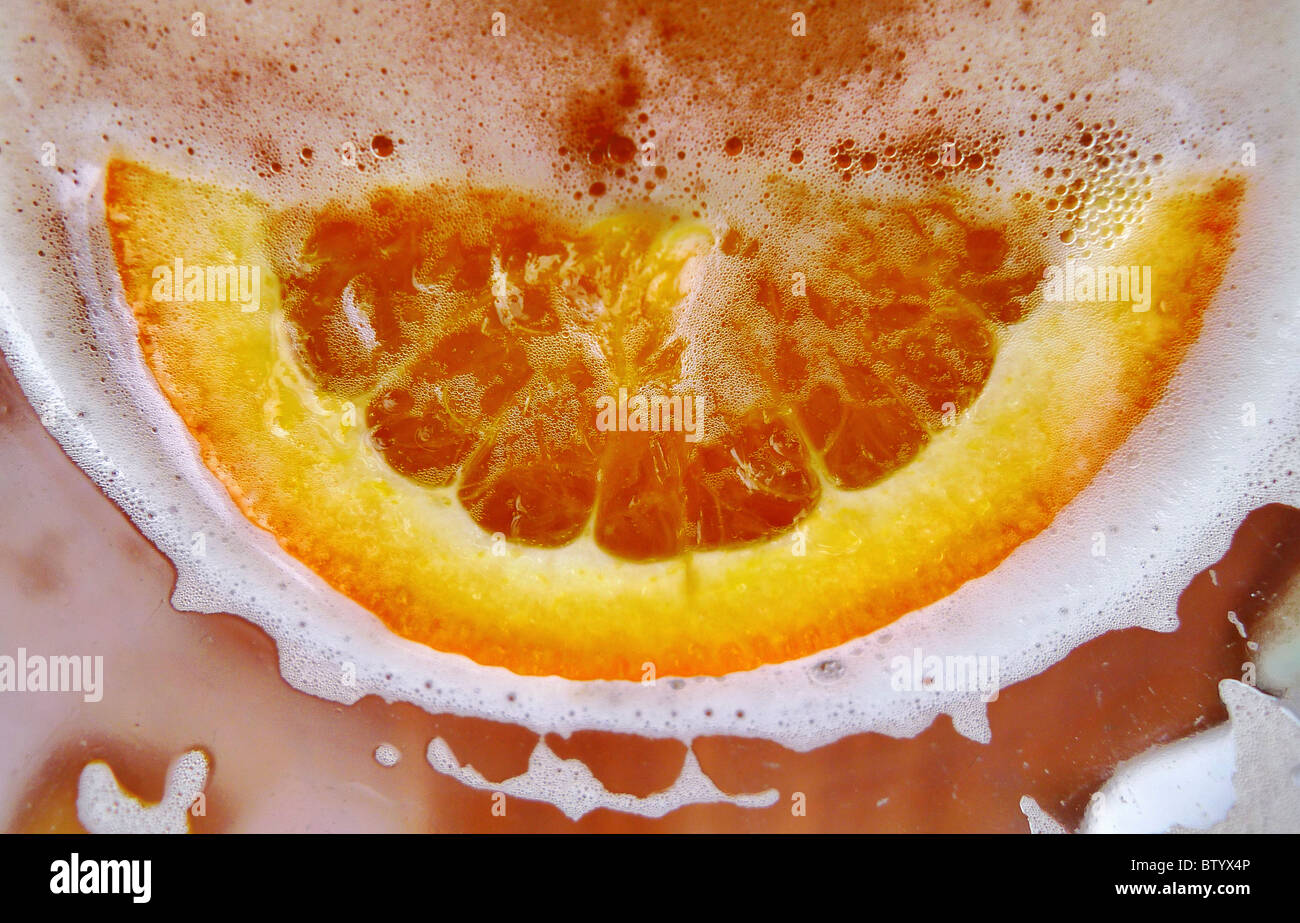 Orange slice floating in a drink Stock Photo - Alamy
