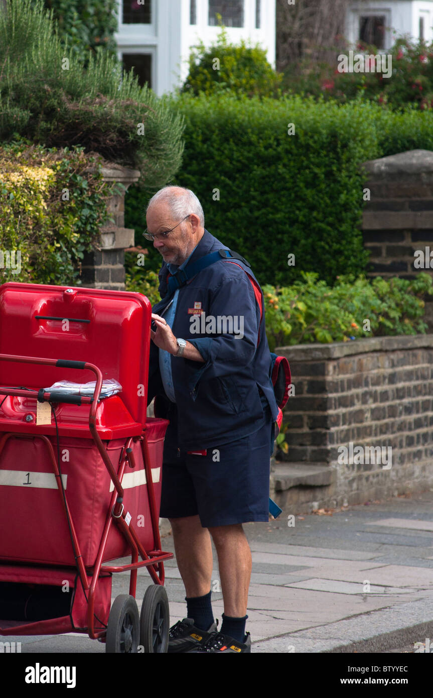 Postman delivering the mail in Enfield, Middlesex, UK Stock Photo - Alamy
