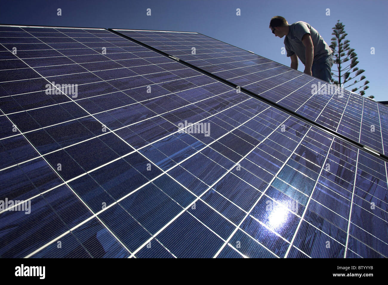 Photovoltaic solar panels being fitted by tradesmen to a house in ...