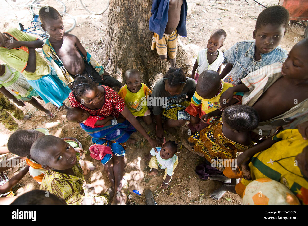 Daily scene in an African village. children and women gather under the ...