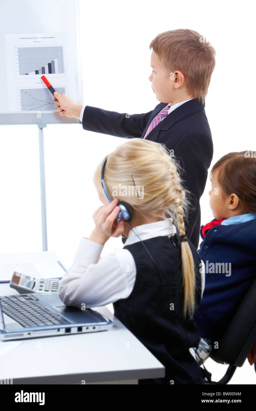 Photo of cute children looking at whiteboard while smart lad presenting ...