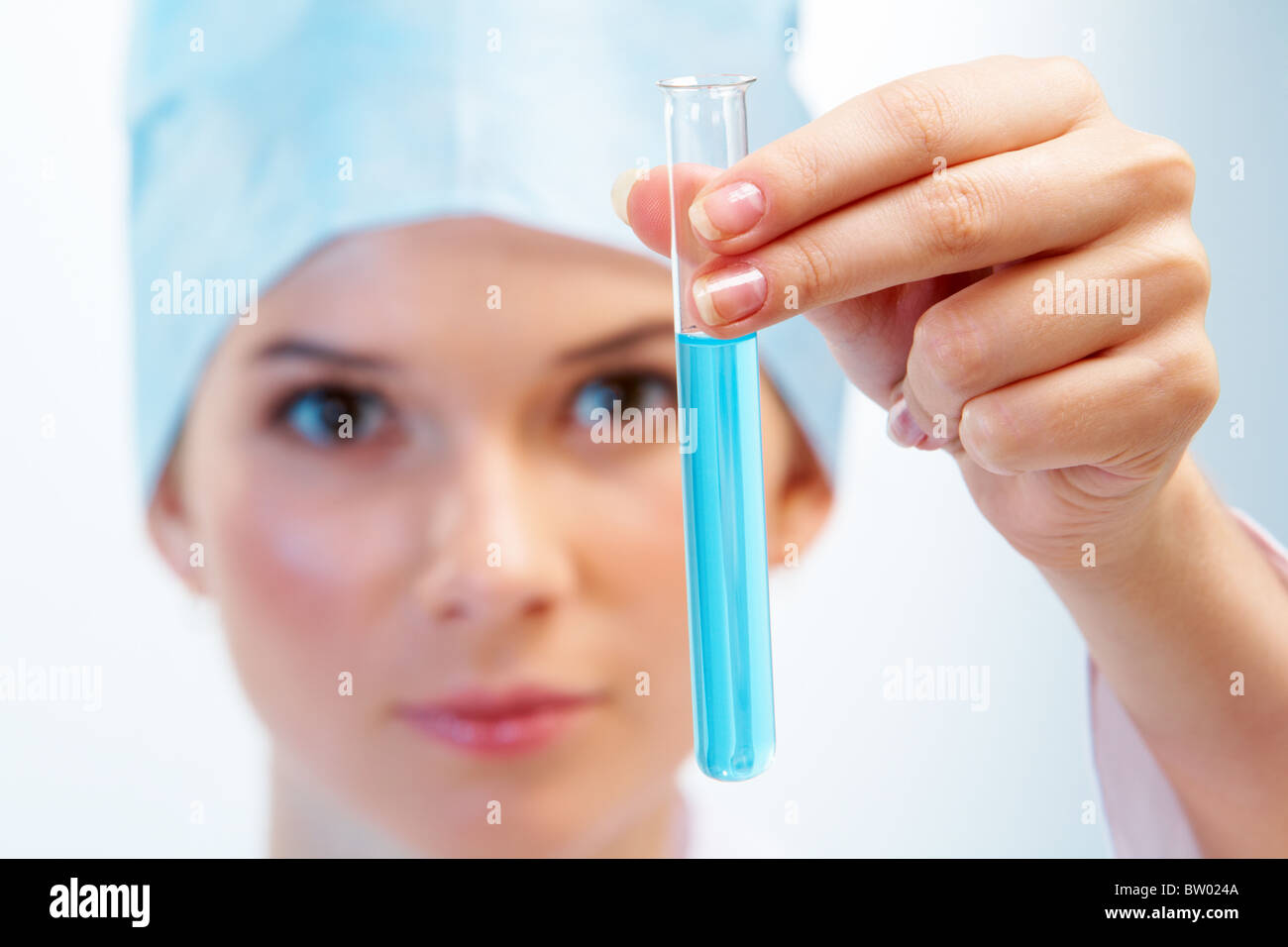 Close-up of glass tube with blue fluid in nurse hand during medical ...