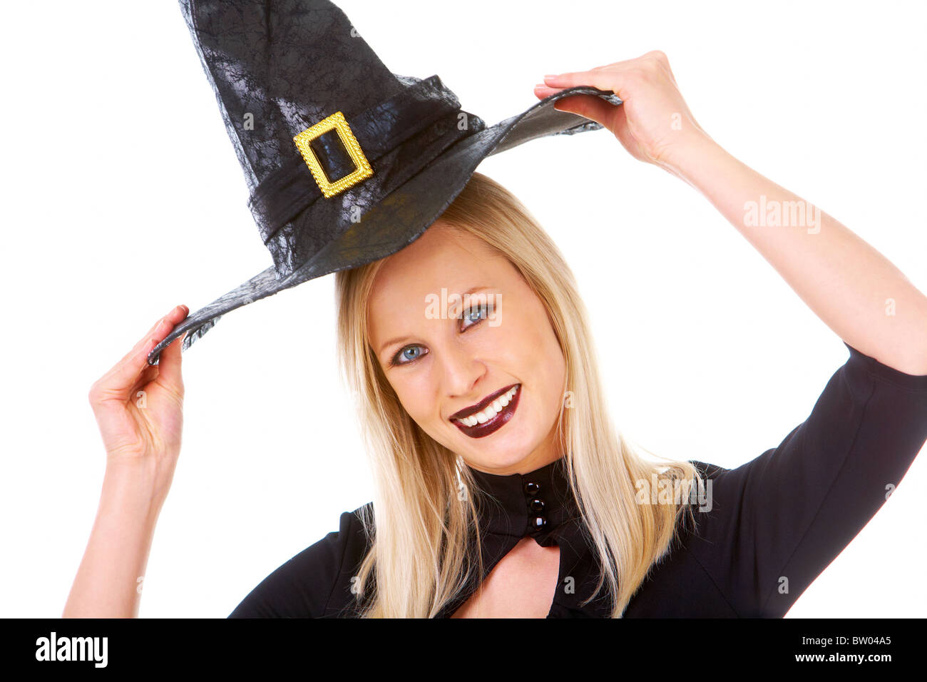 Portrait of young female putting off black hat and keeping it over head ...