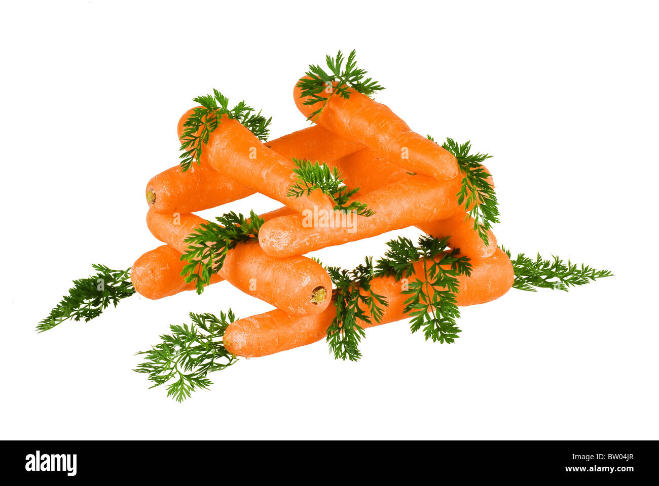 Carrots stacked up with leaves around on white background Stock Photo ...