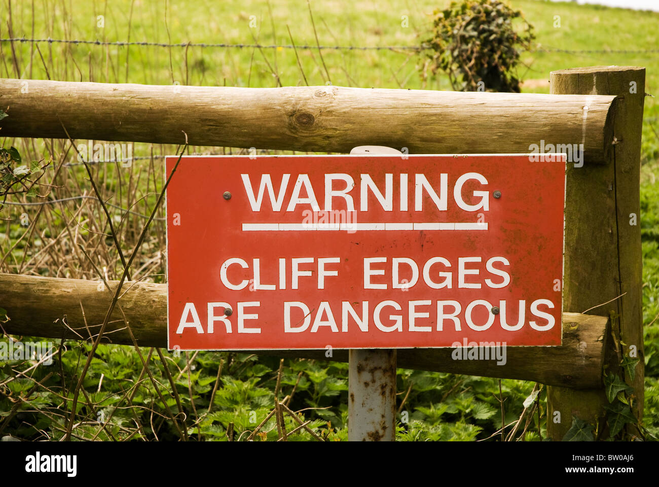 Waring sign reading 'Warning Cliff edges are dangerous' Stock Photo - Alamy