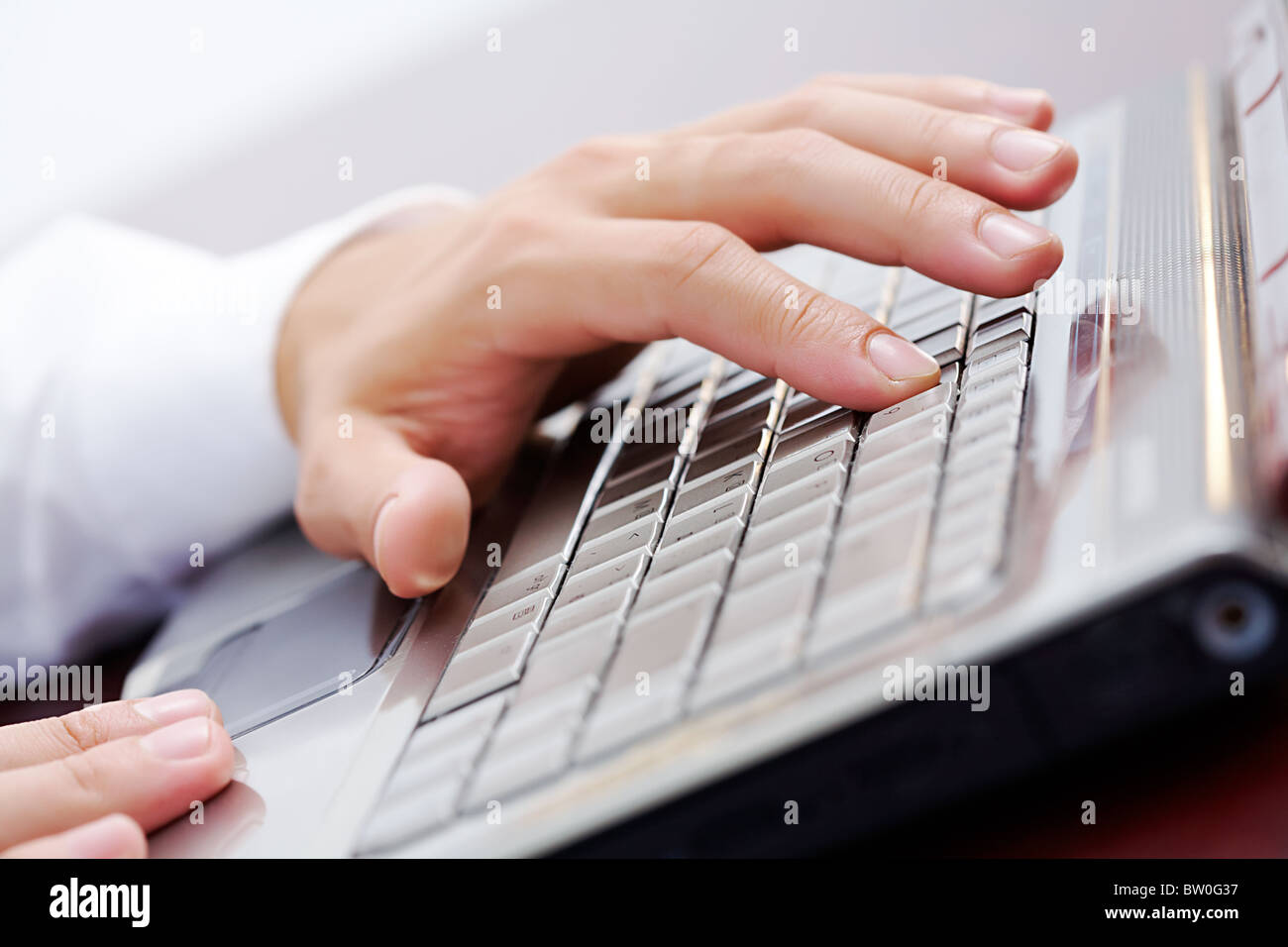 Close-up of male hand touching button of silver laptop keyboard Stock ...