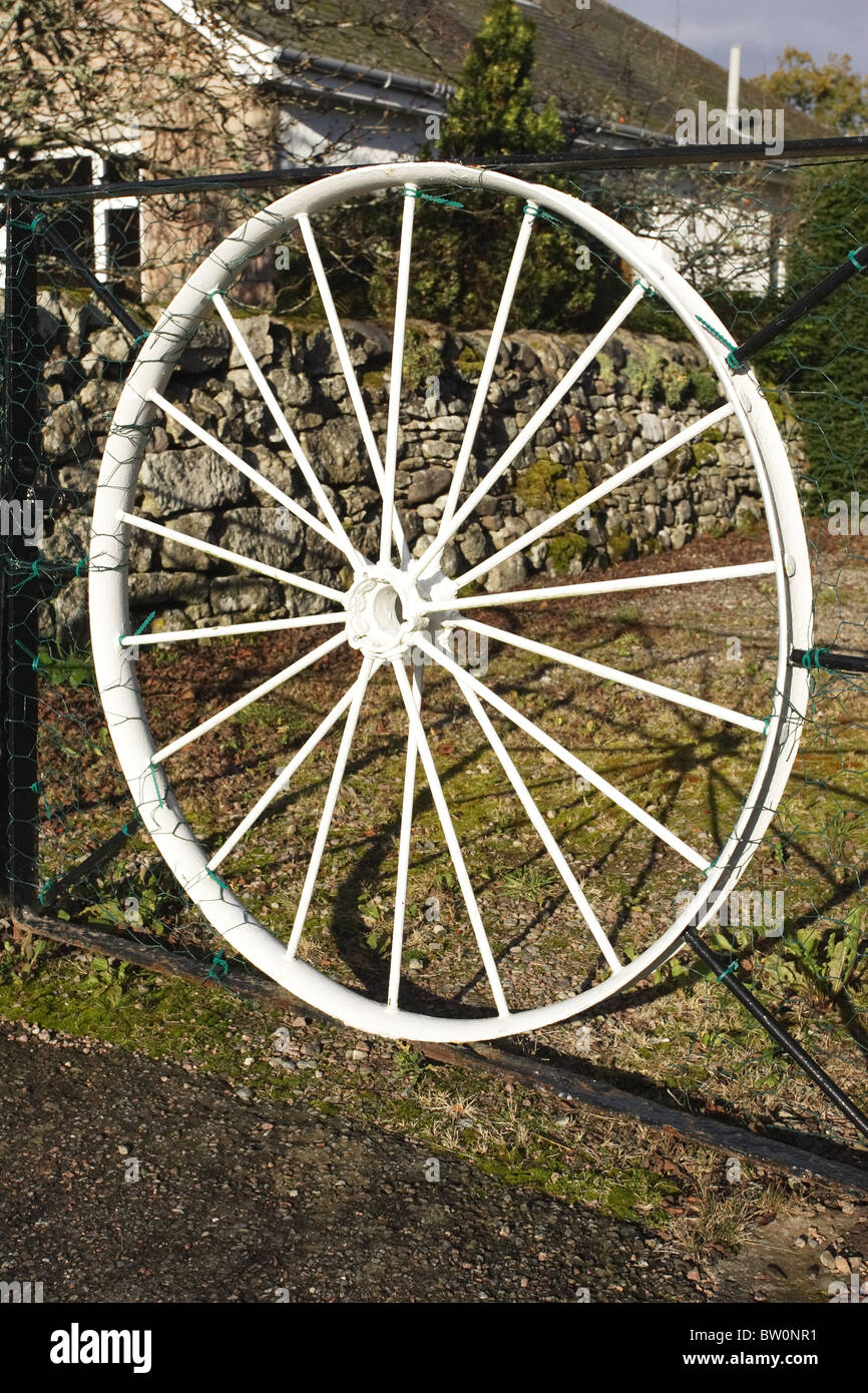 A wrought iron carriage wheel used as an ornate gate feature Stock ...